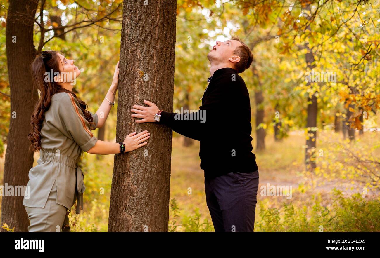 young couple hag the tree in the forest, people connection with nature ...