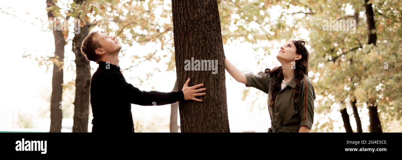 young couple hag the tree in the forest, people connection with nature ...