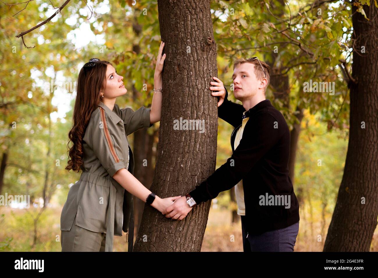 young couple hag the tree in the forest, people connection with nature ...