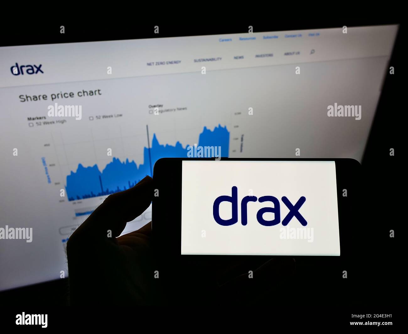 Person holding cellphone with logo of British power company Drax Group ...