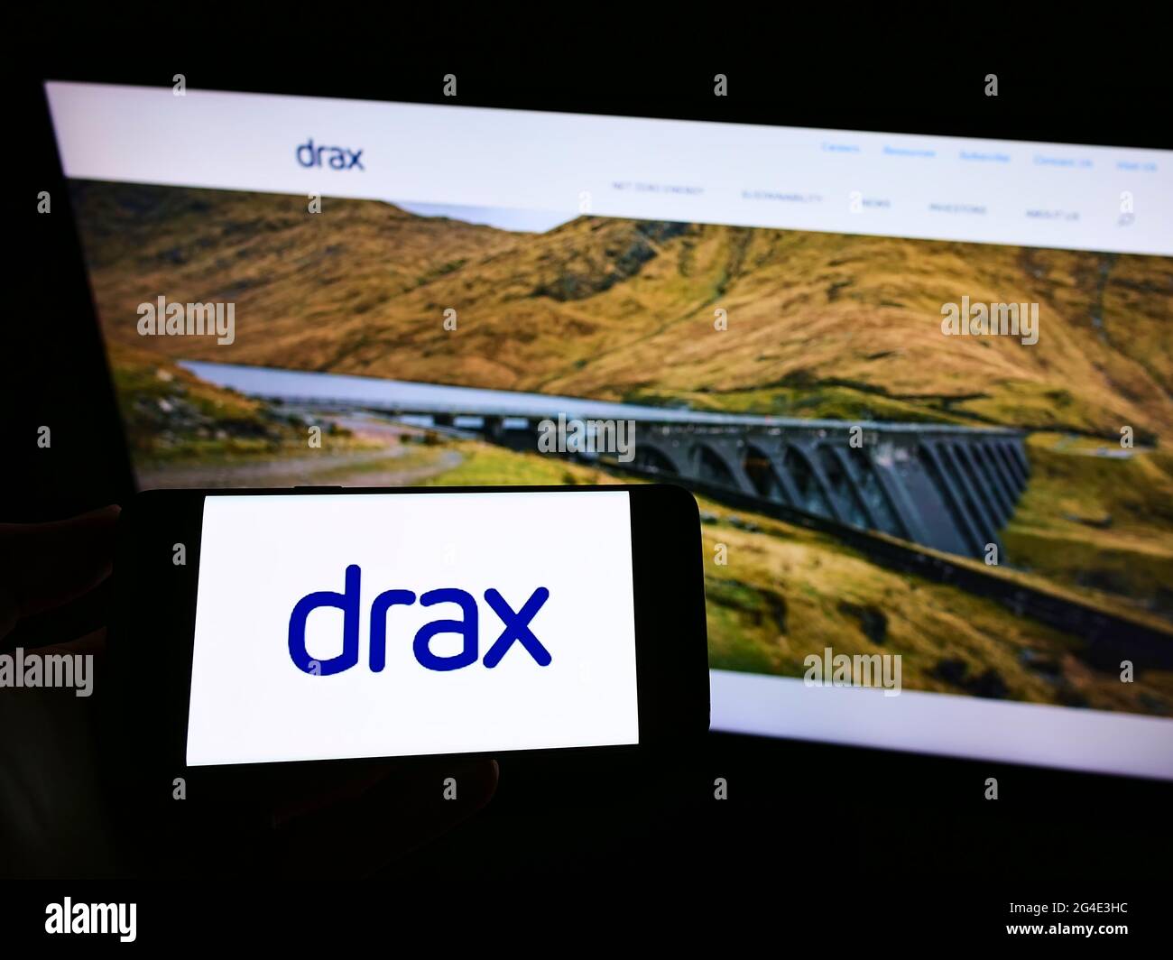 Person holding mobile phone with logo of British power company Drax ...