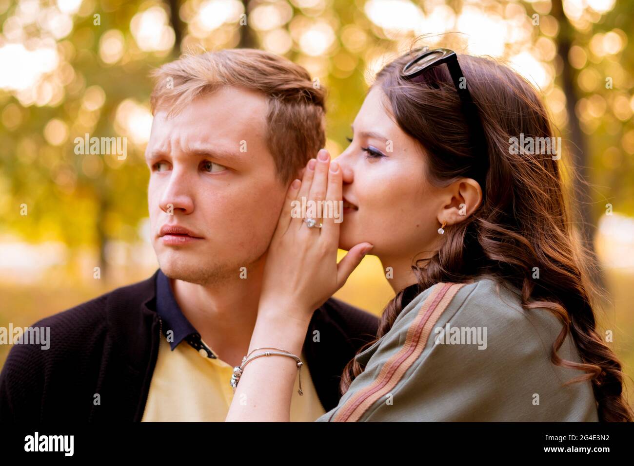 couple of young man and woman tell secret each other, whisper to the ...
