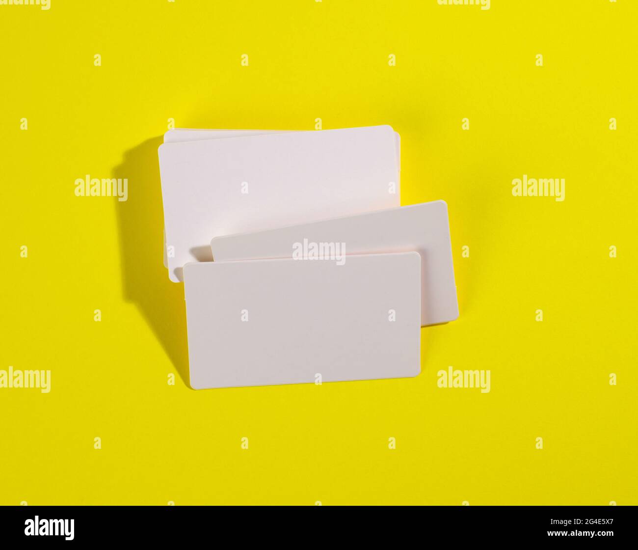 a stack of white rectangular business cards on a yellow background ...
