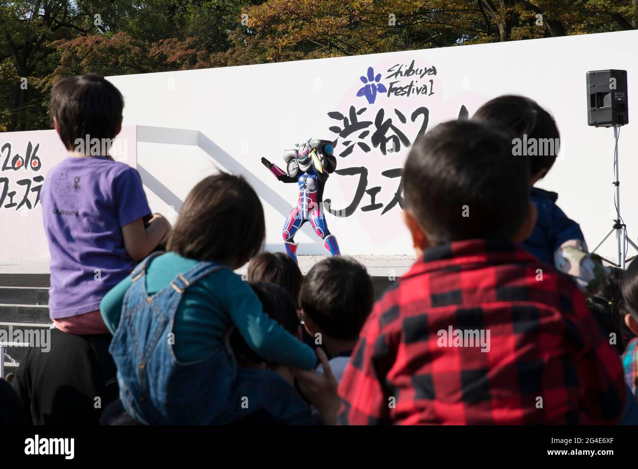 People watching a live action Power Rangers type performance on stage ...