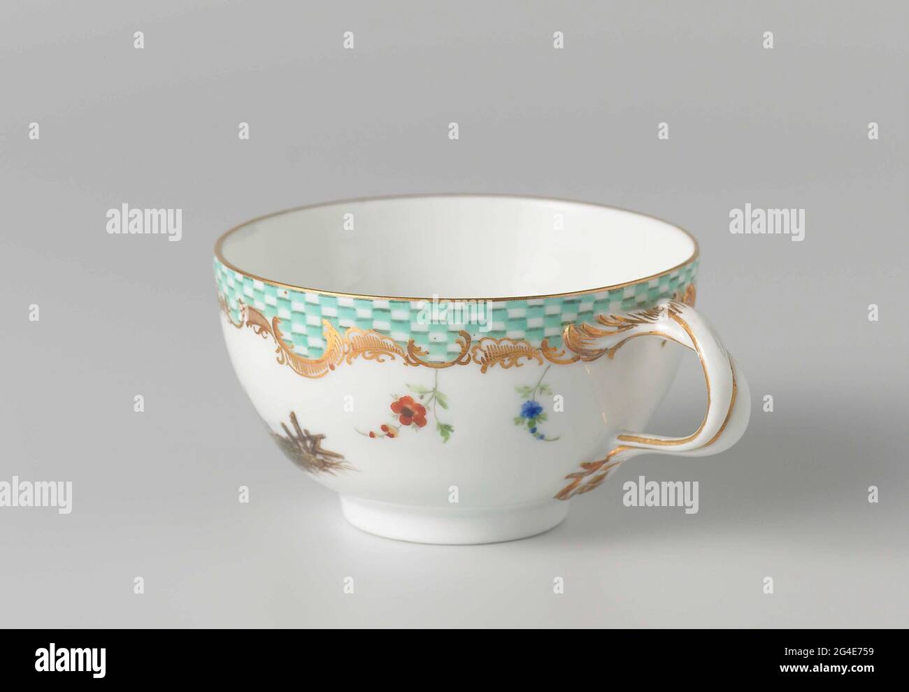 . Low cup with ear, painted porcelain. The head is painted with ...