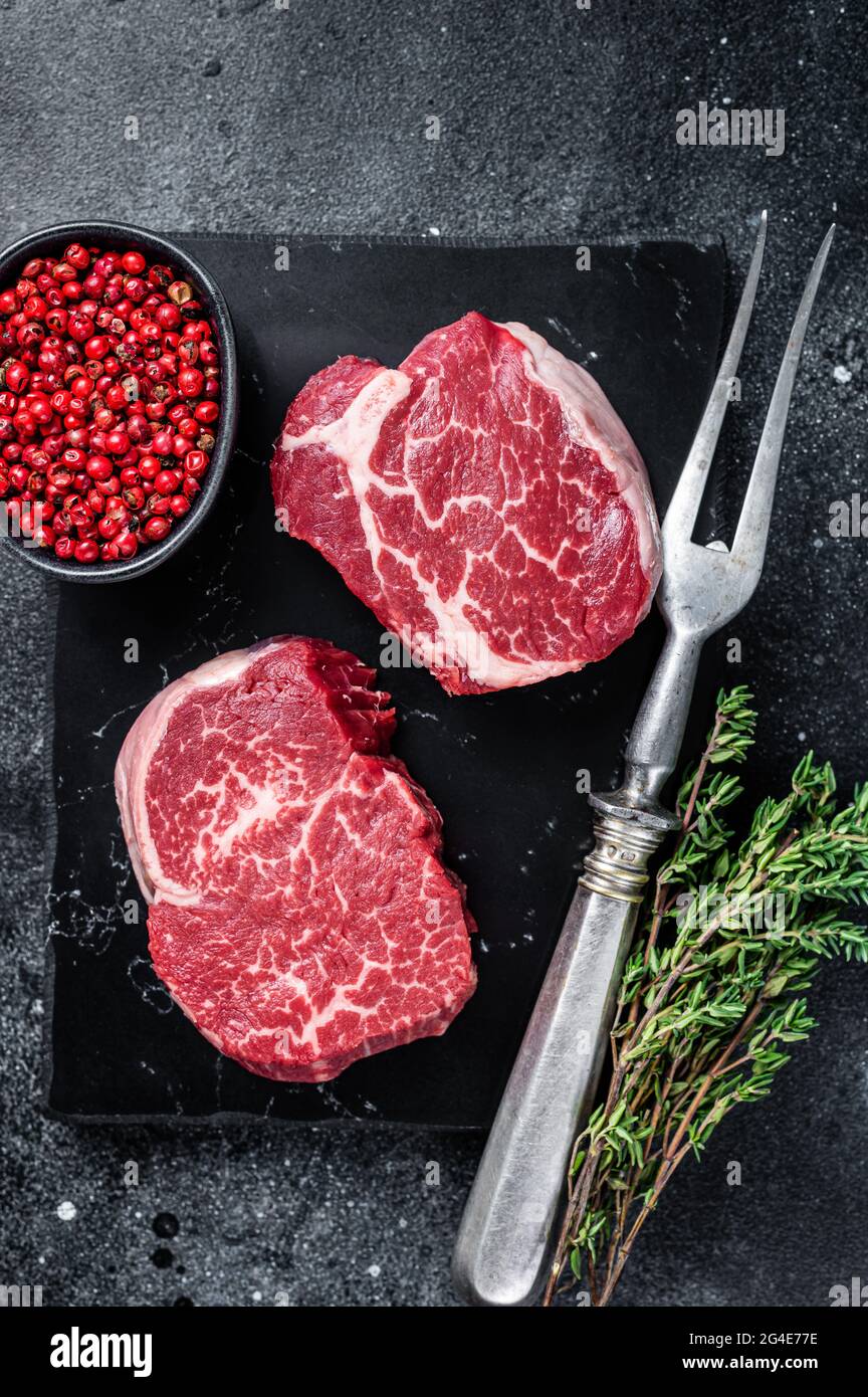 Prime Raw Fillet Mignon tenderloin steaks with thyme. Black background ...