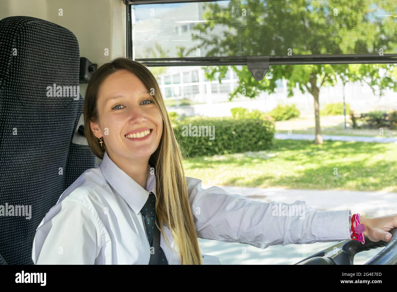 Cheerful young Caucasian female bus driver driving a bus Stock Photo ...