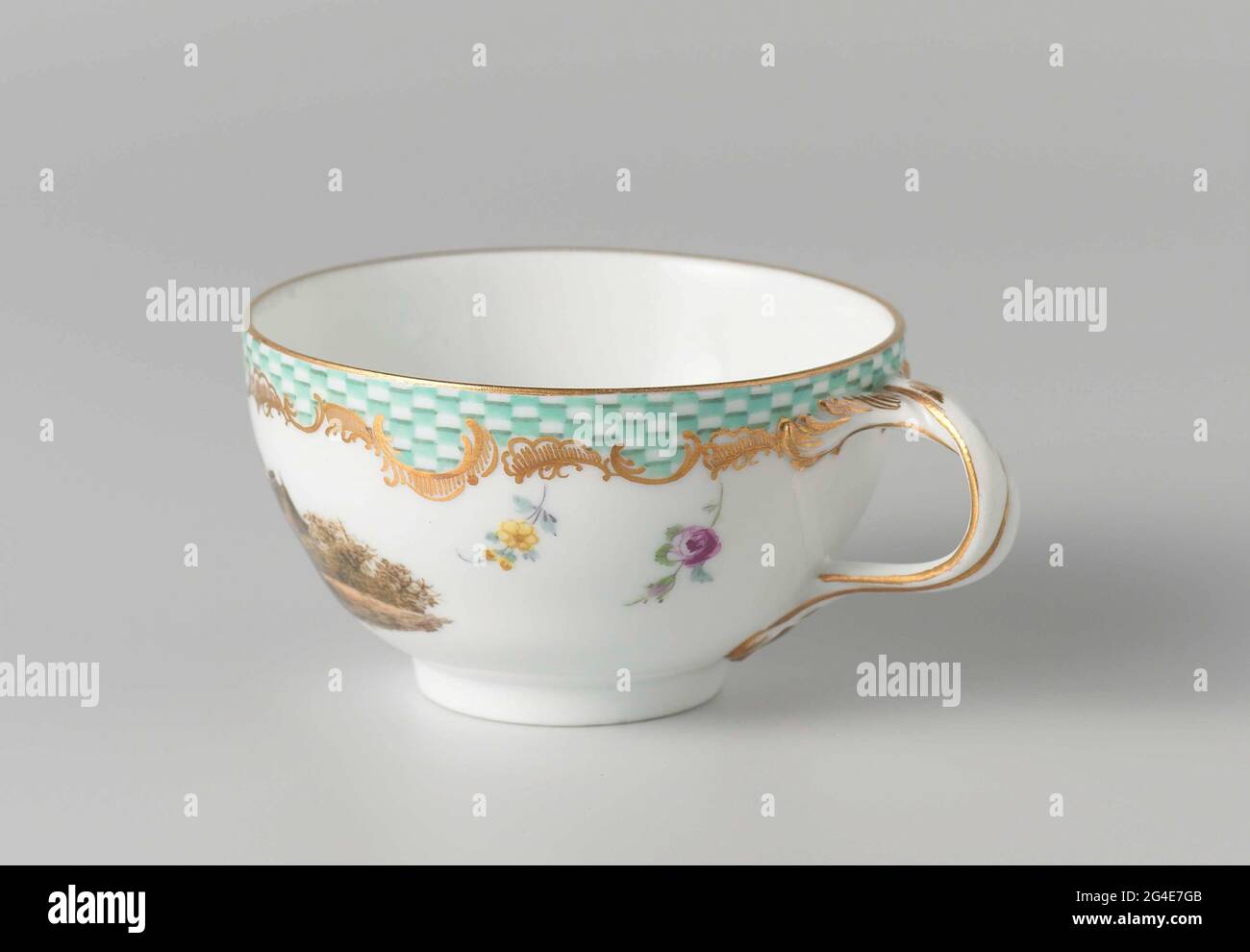 . Low cup with ear, painted porcelain. The head is painted with ...