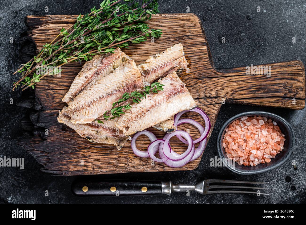 Sardine fish fillet in olive oil on wooden board. Black background. Top ...