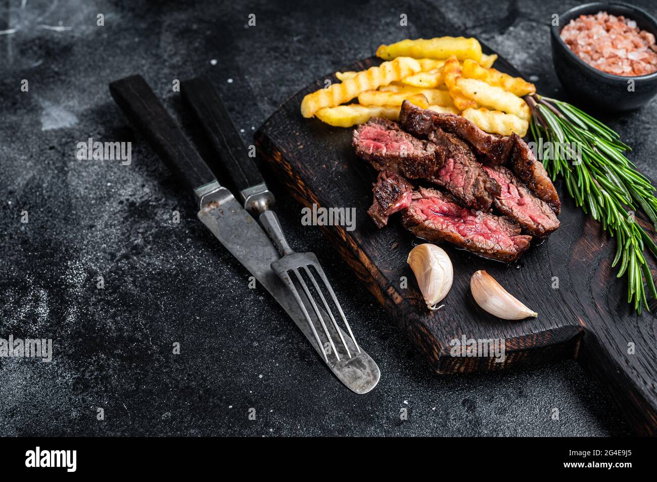 Roasted sliced machete skirt beef meat steak on wooden board with ...