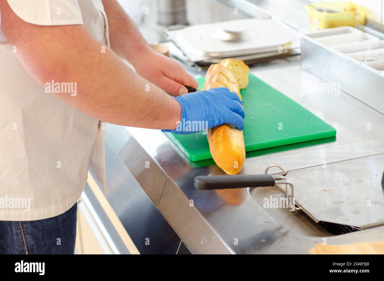 A closeup shot of a baker slicing bread on a chopping board Stock Photo ...