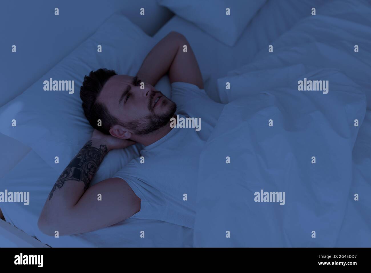 Insomnia and sleeplessness concept. Depressed man unable to sleep ...