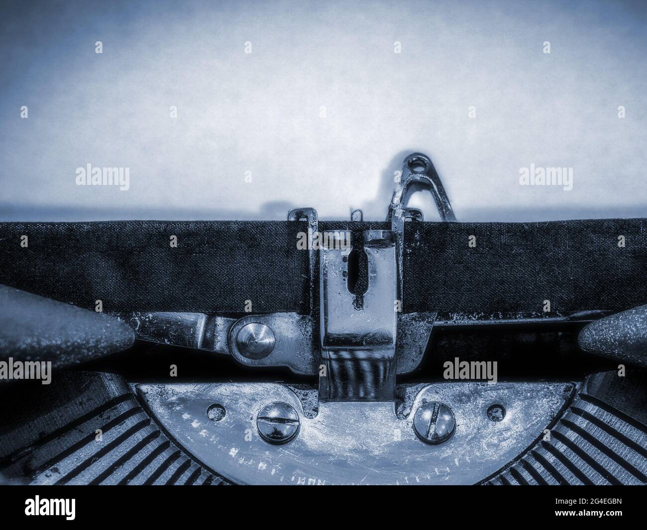 Typewriter close-up with a blank sheet of paper loaded in a Blue tone ...