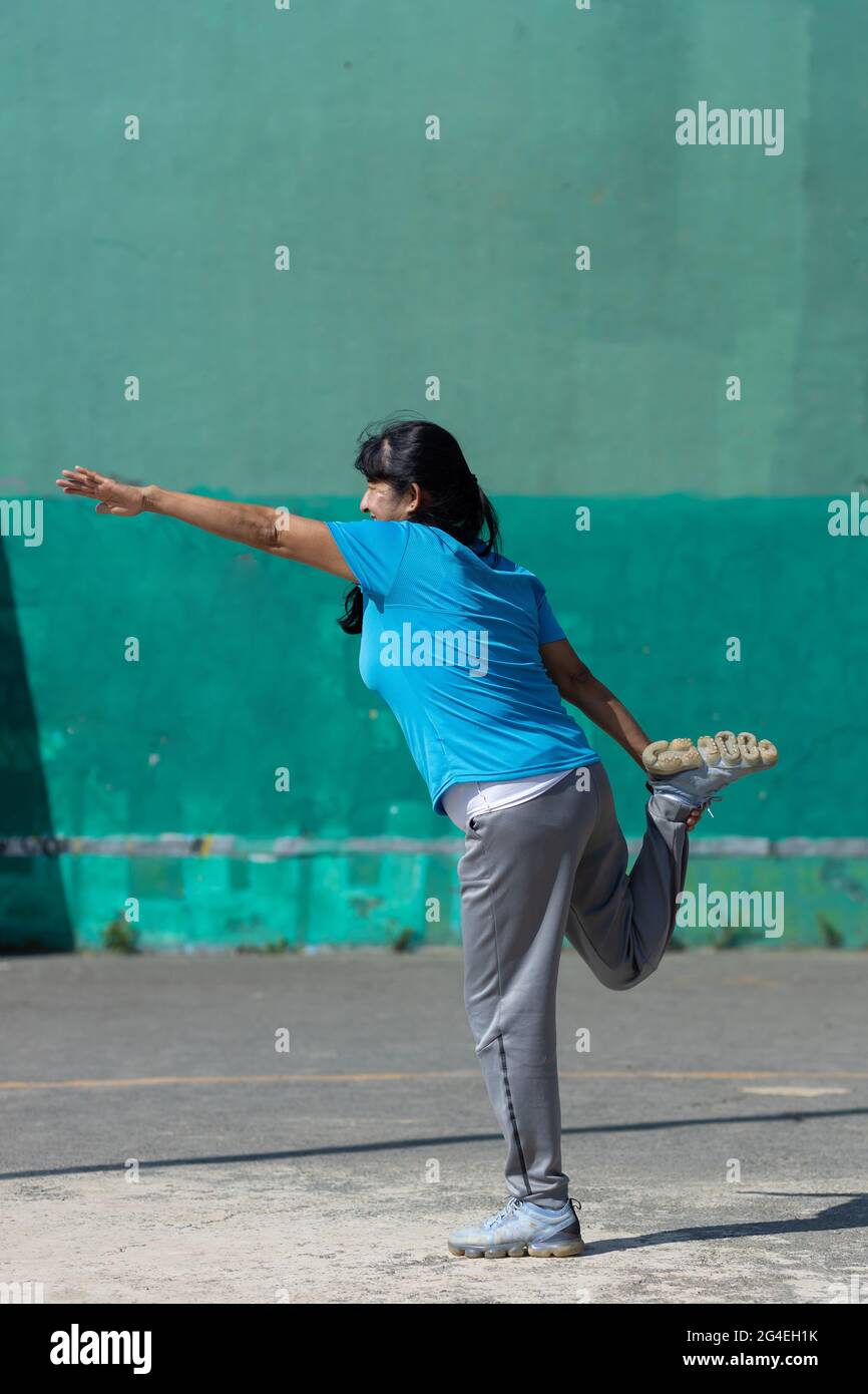 Side view of an energetic Mexican female stretching the leg Stock Photo ...