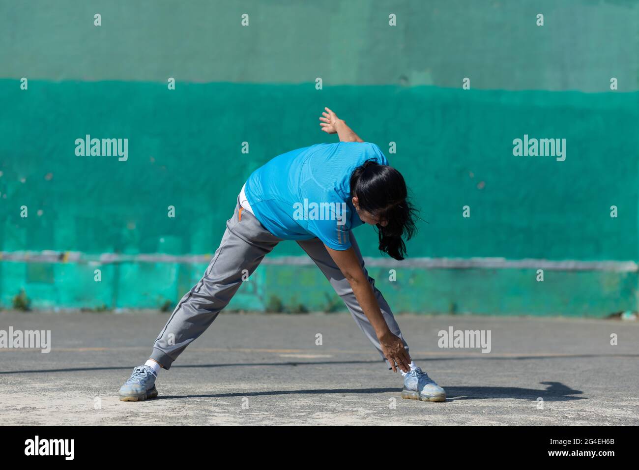 Mexican female bending forward during the outdoor workout Stock Photo ...