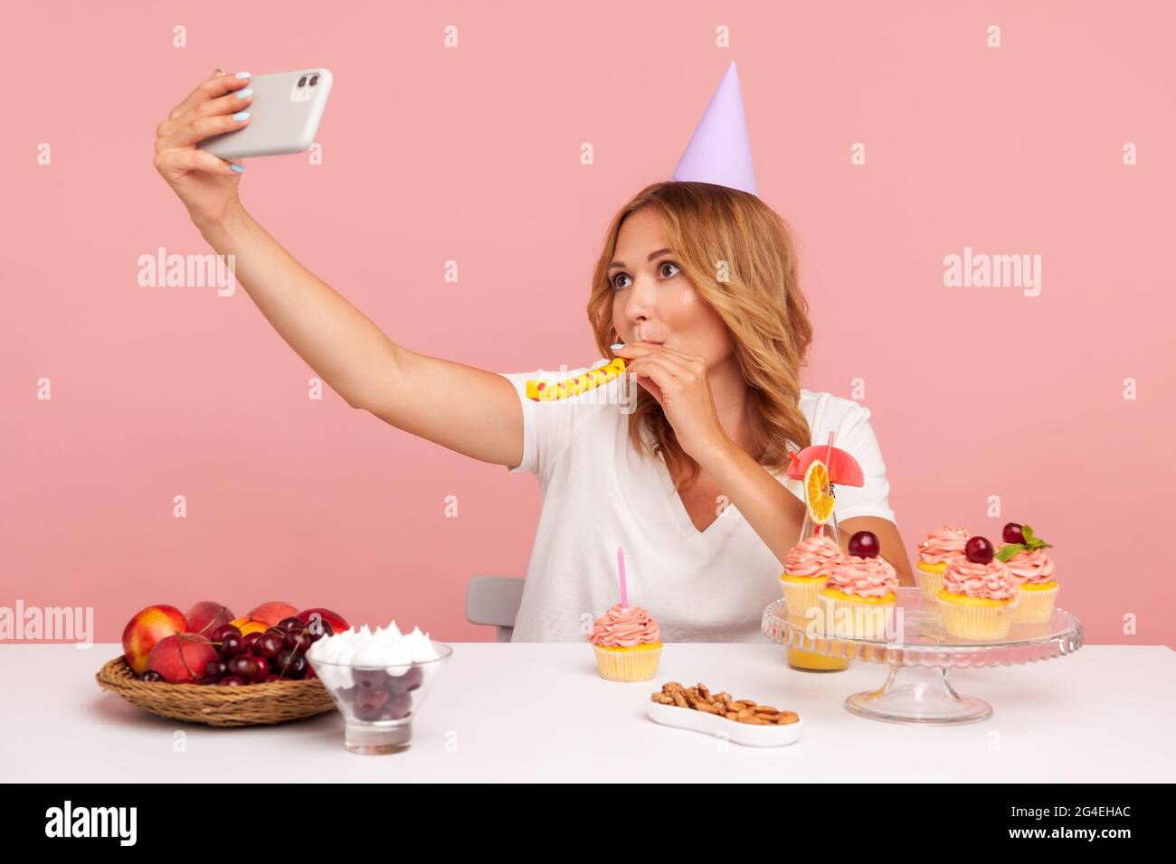 Happy blogger broadcasting livestream with phone and blowing horn to ...