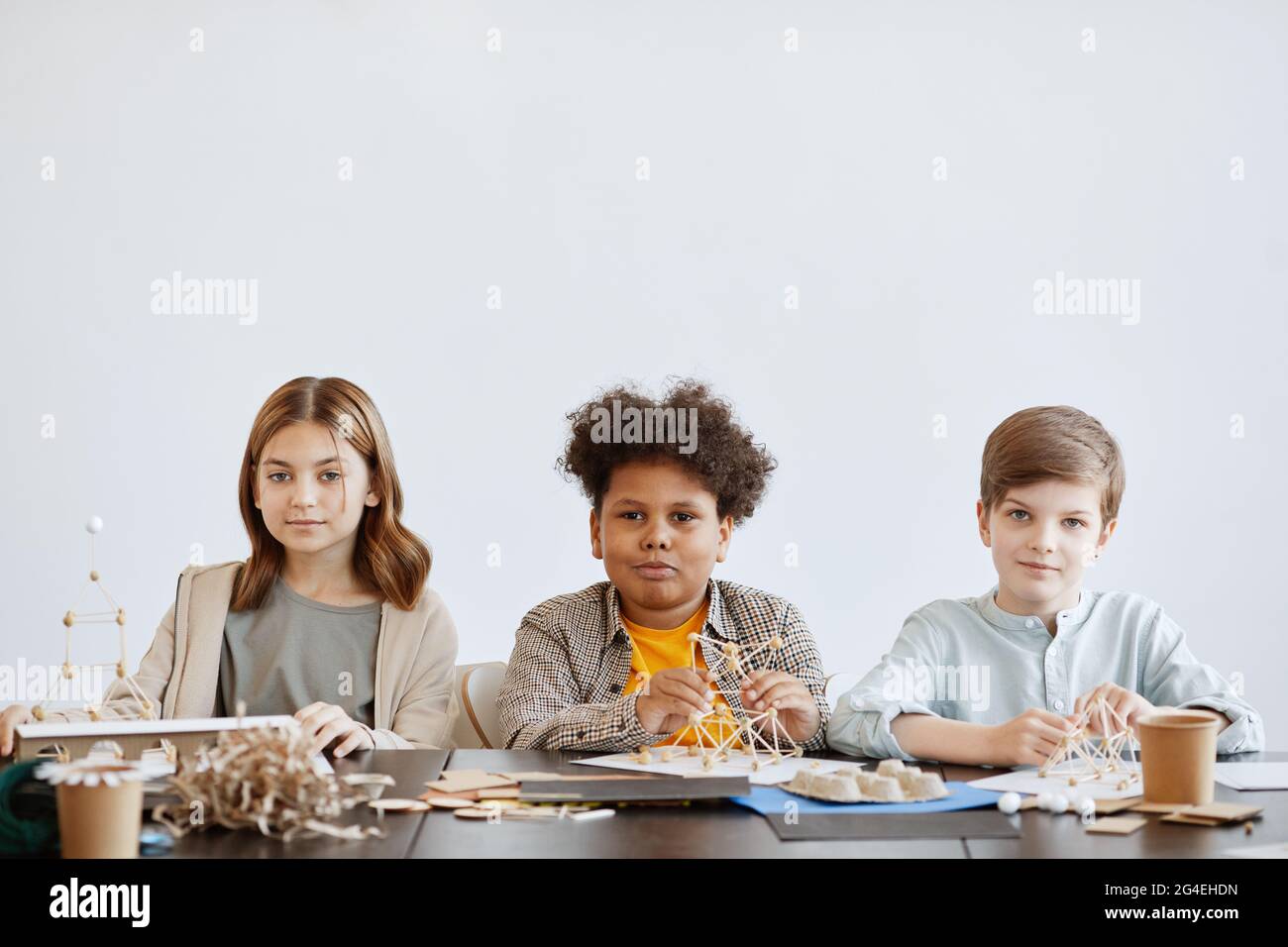 Front view at group of children making wooden models during art and ...