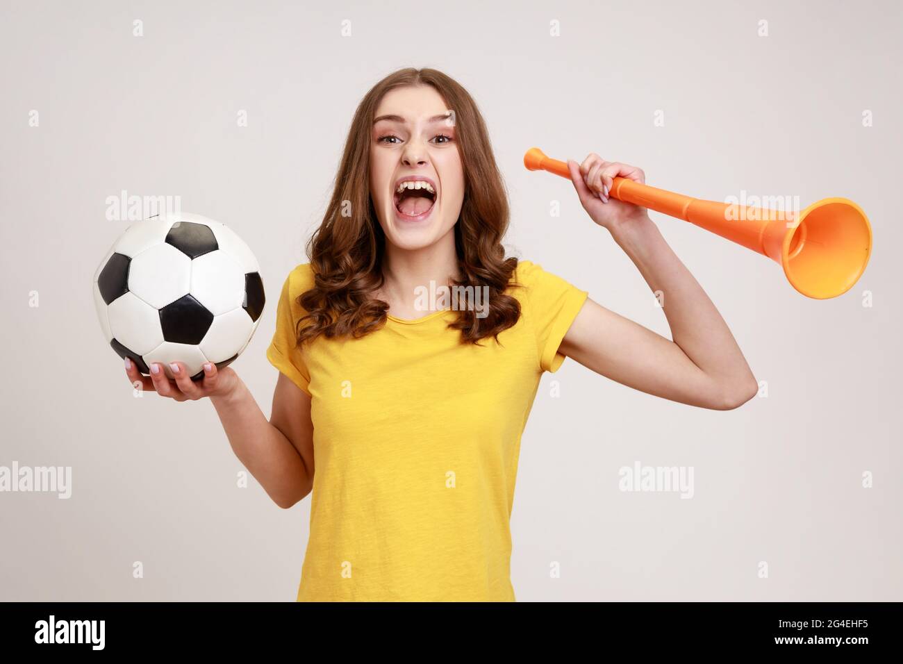 Portrait of cheerful woman of young age with brown hair in yellow t ...