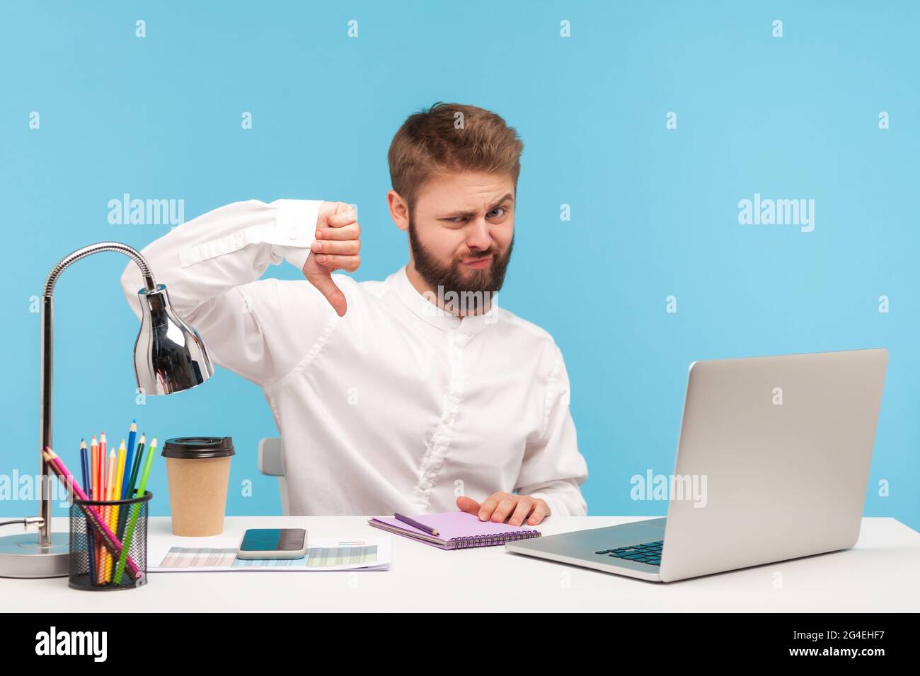 Dislike! Displeased man employee sitting office workplace showing ...