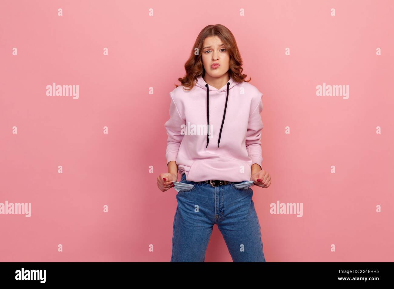 Portrait of upset poor student girl in hoodie and jeans turning out ...