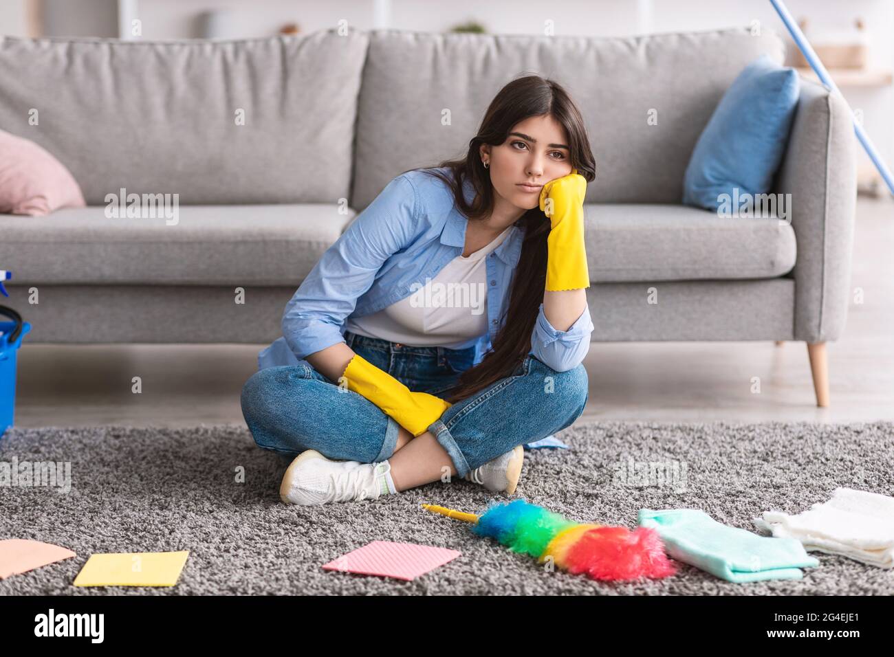 Upset woman tired of cleaning sitting on rug floor carpet Stock Photo ...