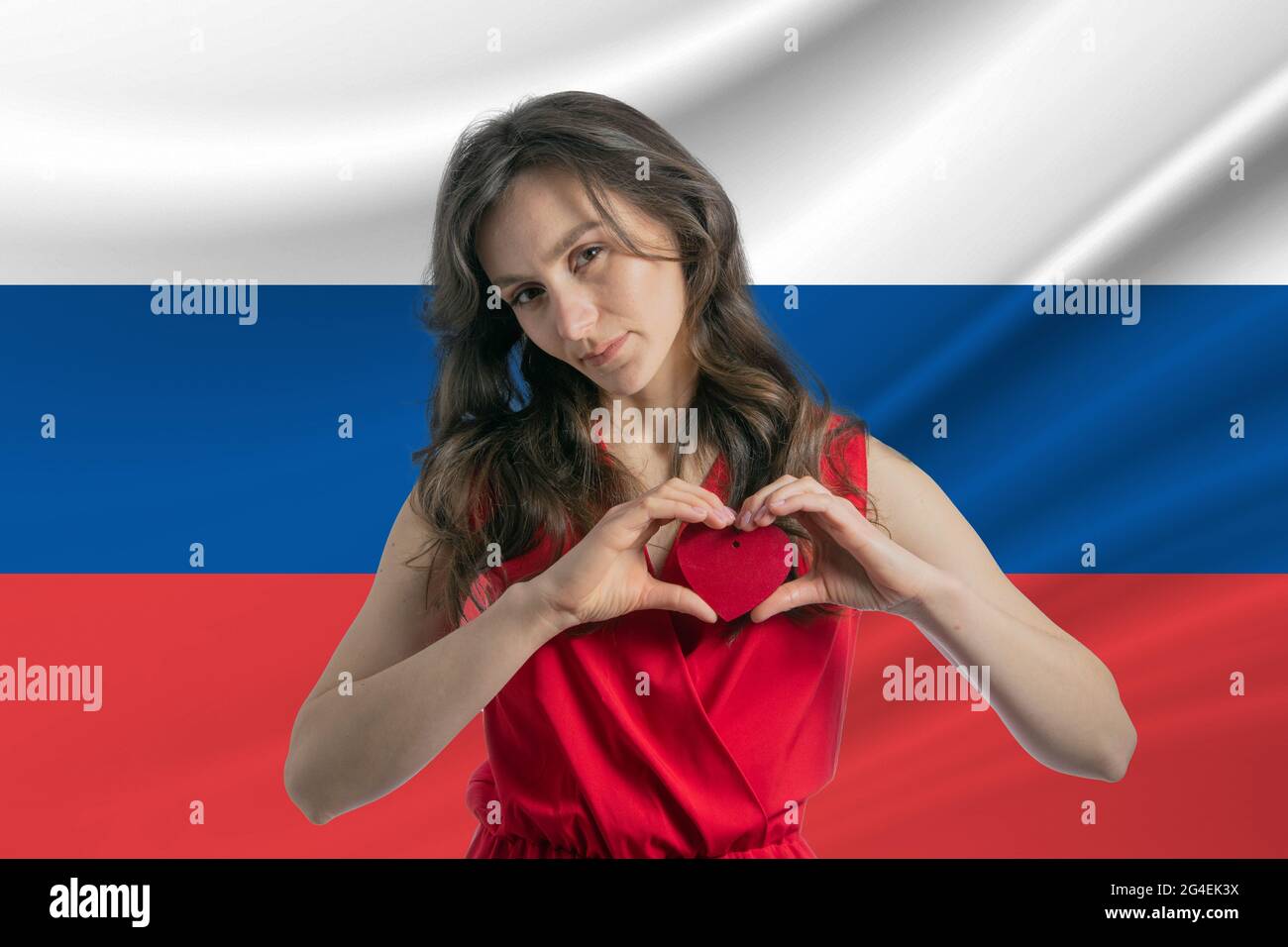 Love Russia. A girl holds a heart on her chest in her hands against the ...