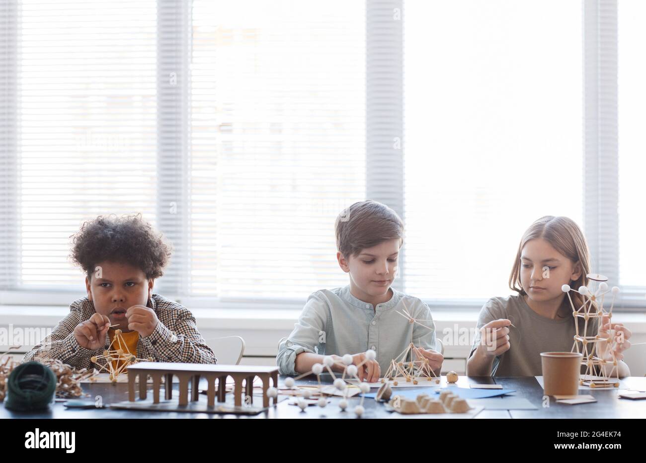 Front view at group of children making wooden models during art and ...