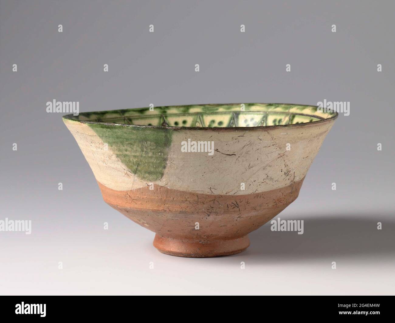 . Come of pottery decorated with sgraffito curlwork on Engobe of white ...