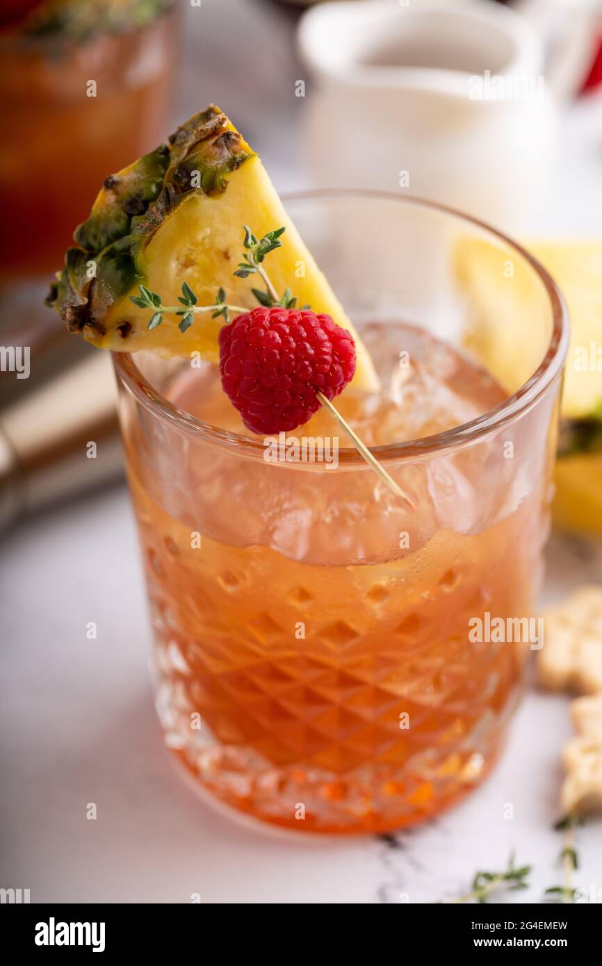 Raspberry pineapple refreshing cocktail with thyme sprig Stock Photo ...
