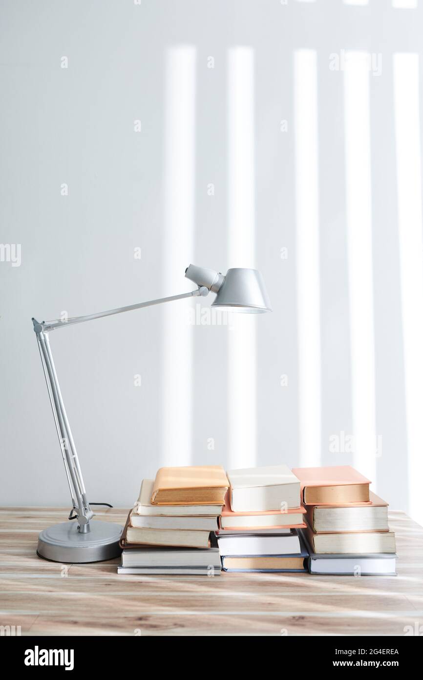 Many students books on big table with modern lamp Stock Photo - Alamy