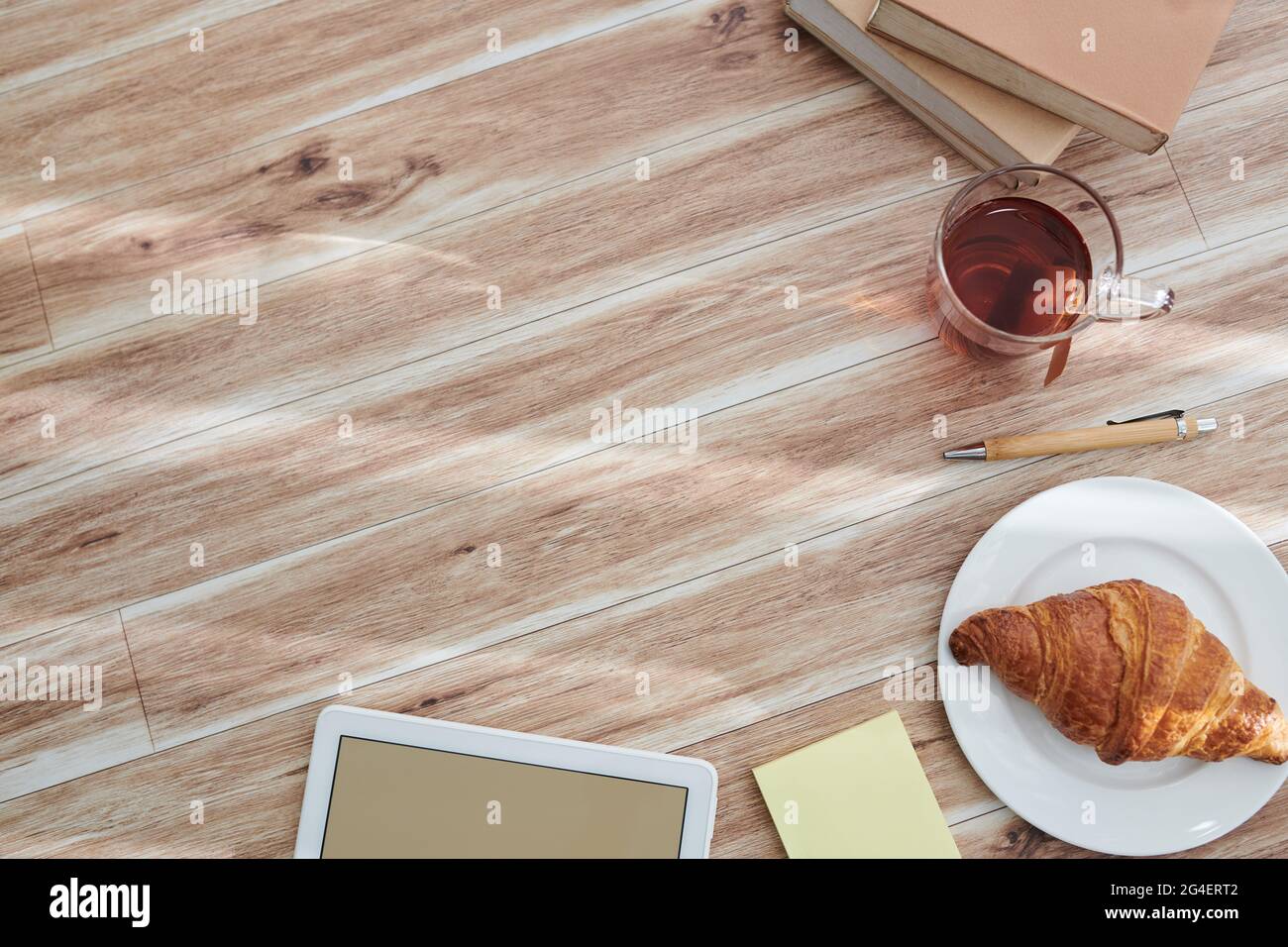 Office desk background with cup of tea and croissant, table computer ...