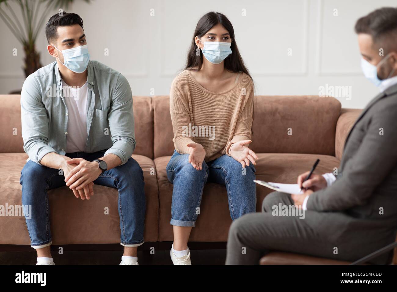 Couple talking at therapy session with professional male therapist ...