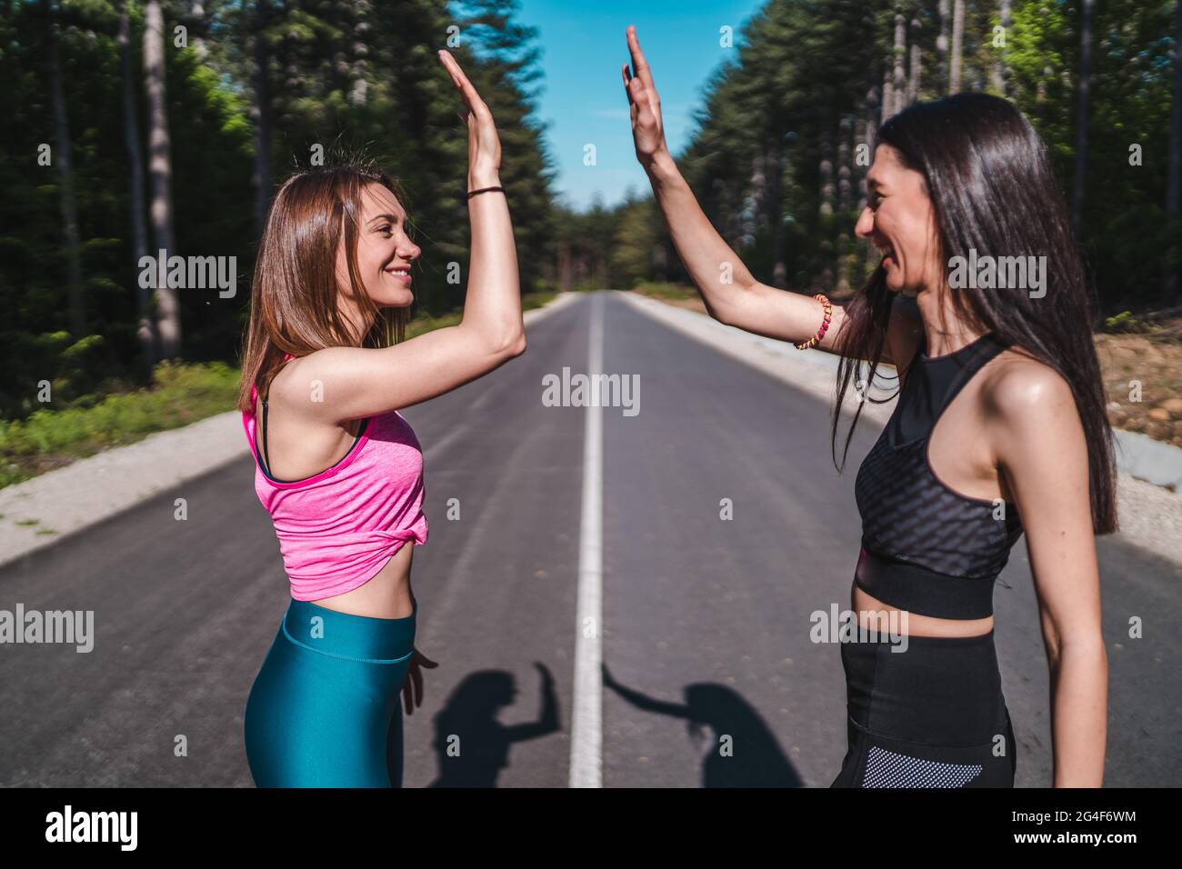Smiling Female runners giving high five before workout Stock Photo - Alamy