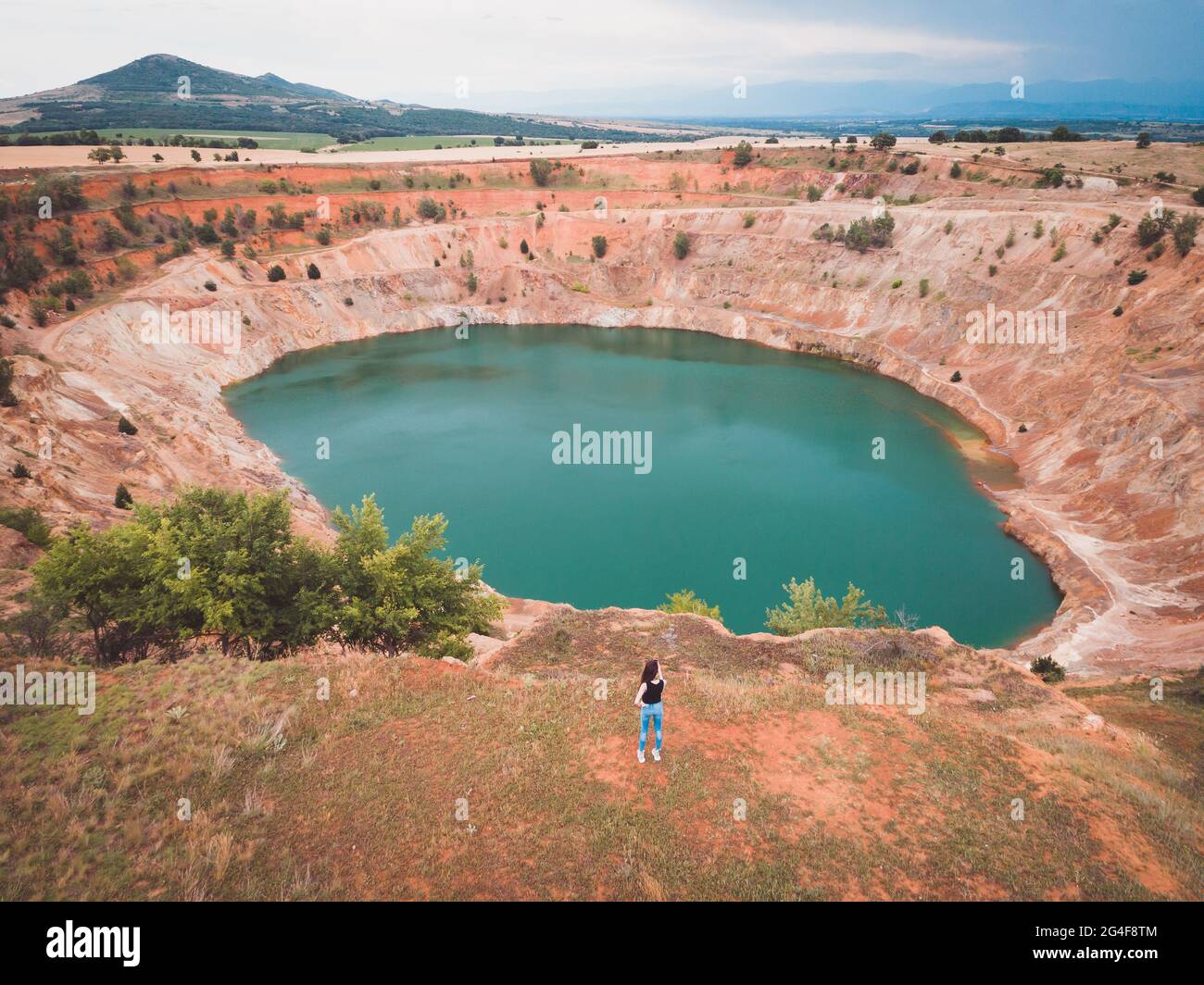 Young woman taking photos of filled with water copper mine Stock Photo ...