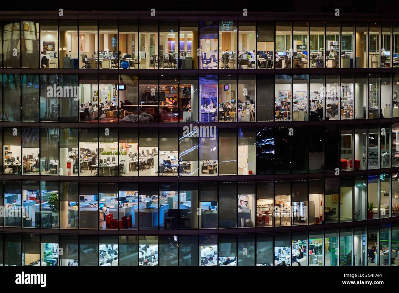 Office windows at night with people working Stock Photo - Alamy