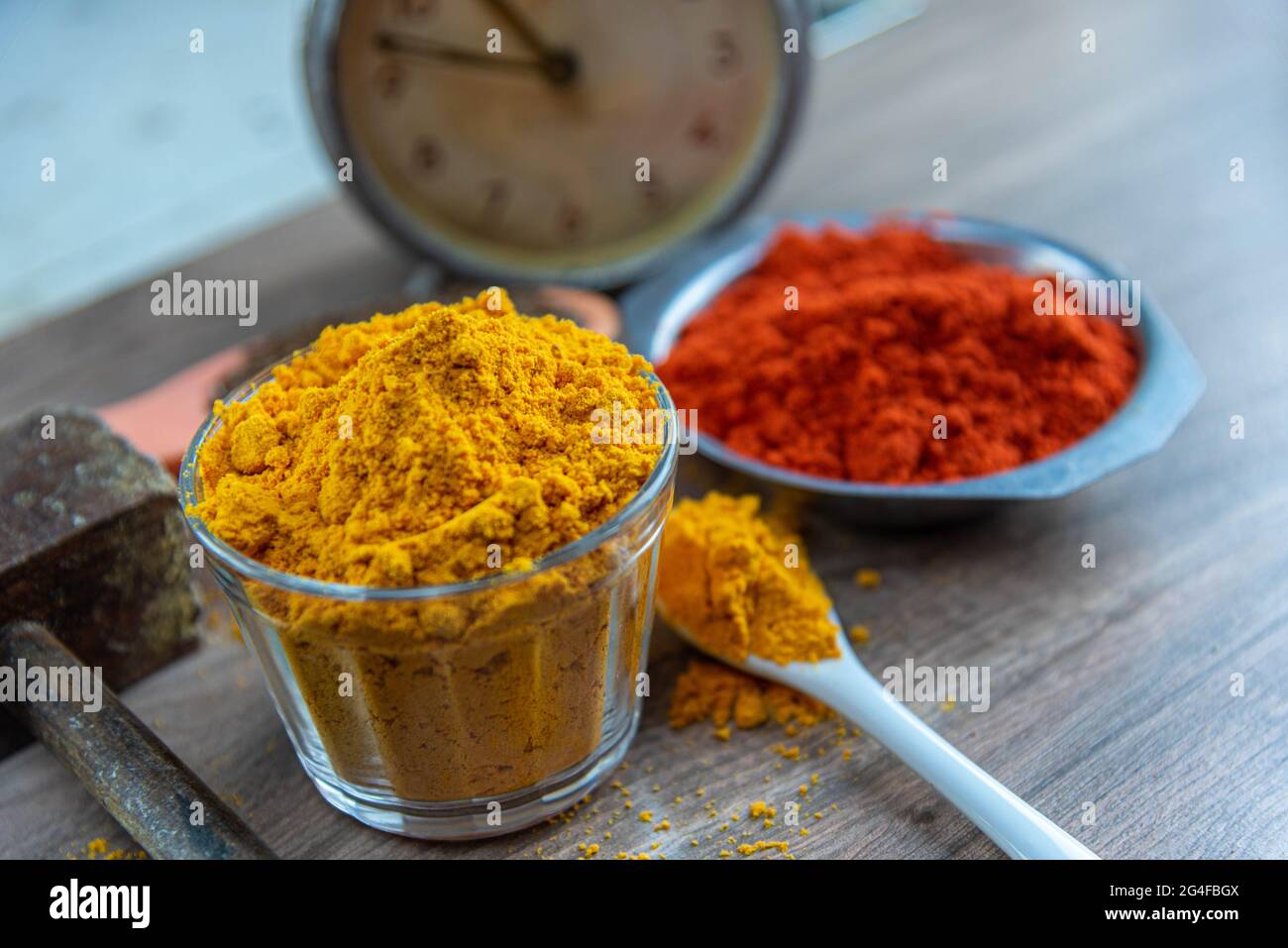 Colorful culinary spices and clock on wooden surface. Condiments used ...