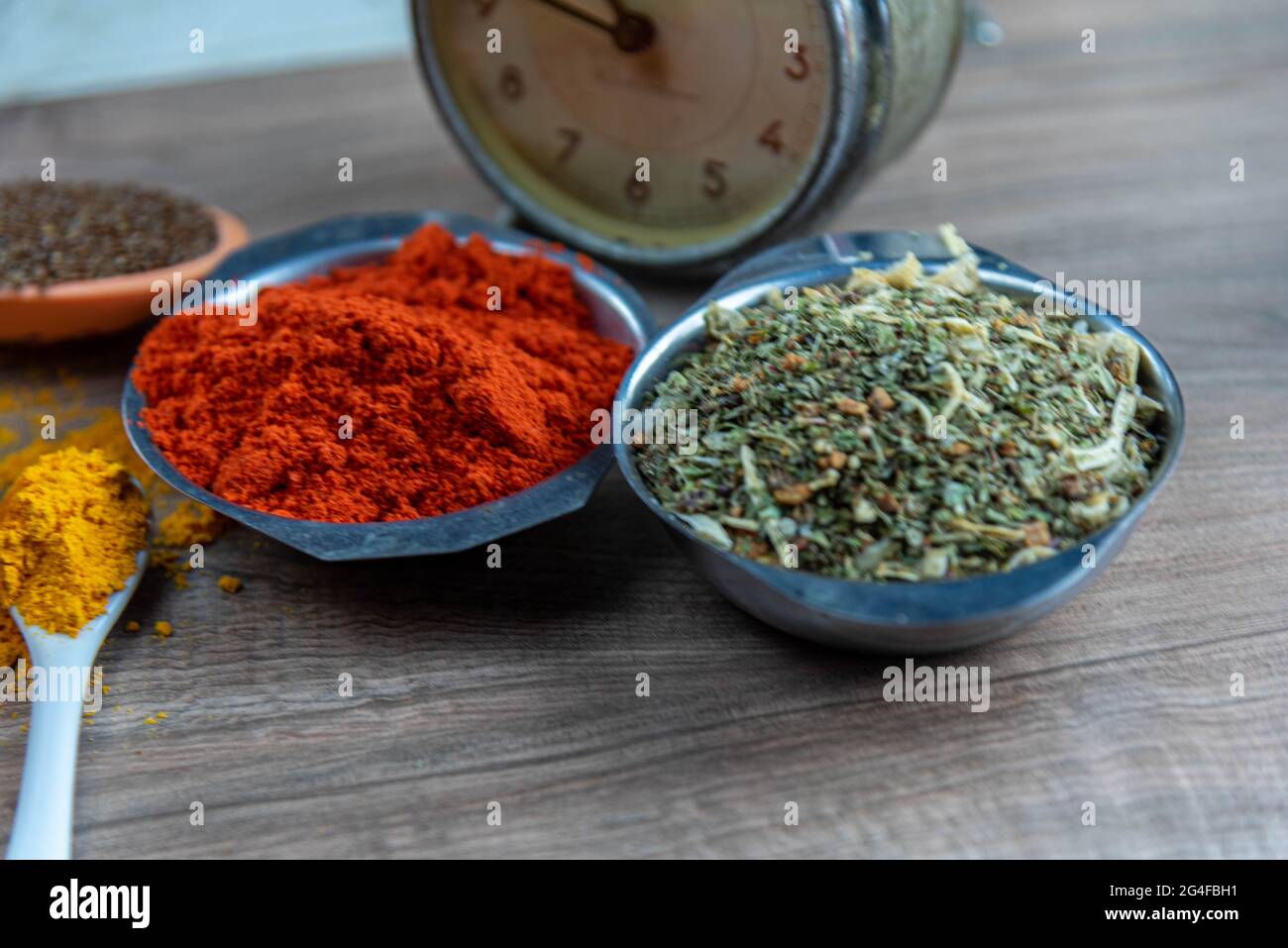 Colorful culinary spices and clock on wooden surface. Condiments used ...