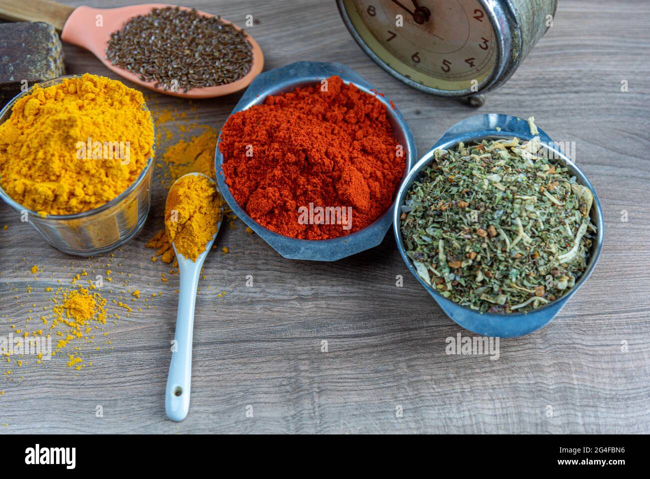 Colorful culinary spices and clock on wooden surface. Condiments used ...