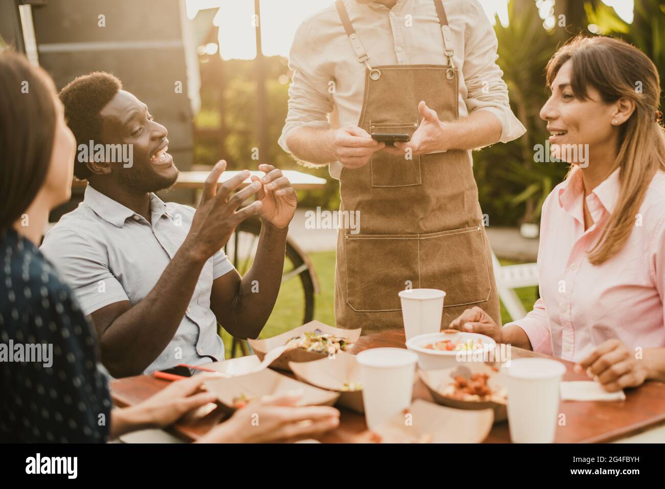 Diverse friends making order in outdoor cafe Stock Photo - Alamy