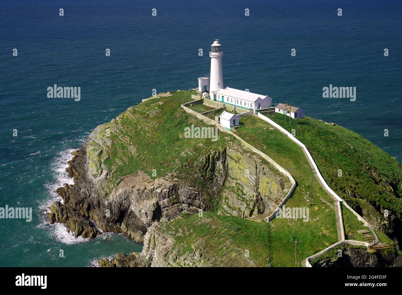 White lighthouse on rocky island, sea, South Stack, Holyhead, Wales ...