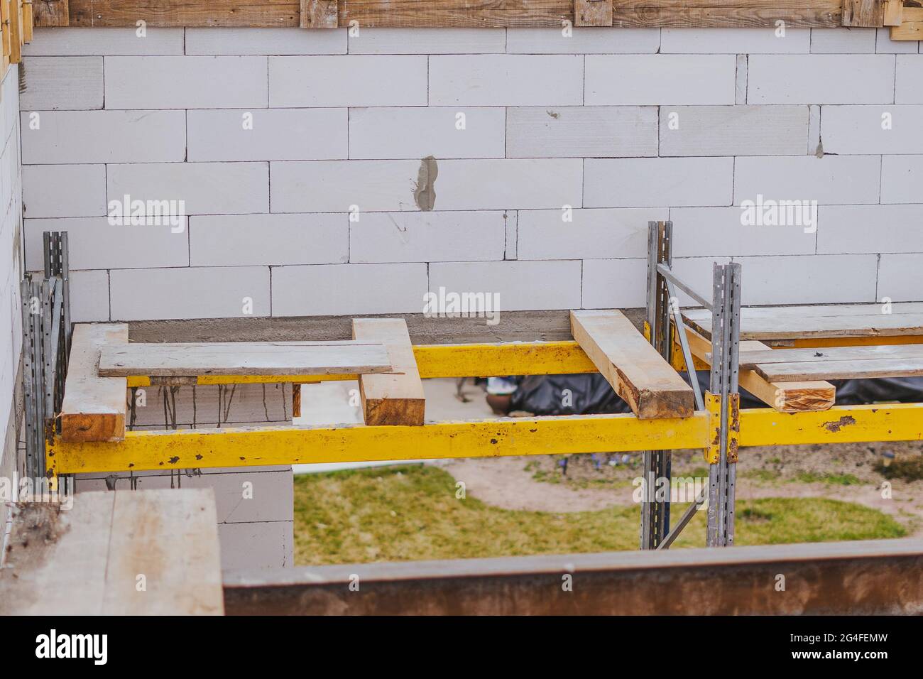 Yellow scaffolding installed on a construction site near the wall Stock ...