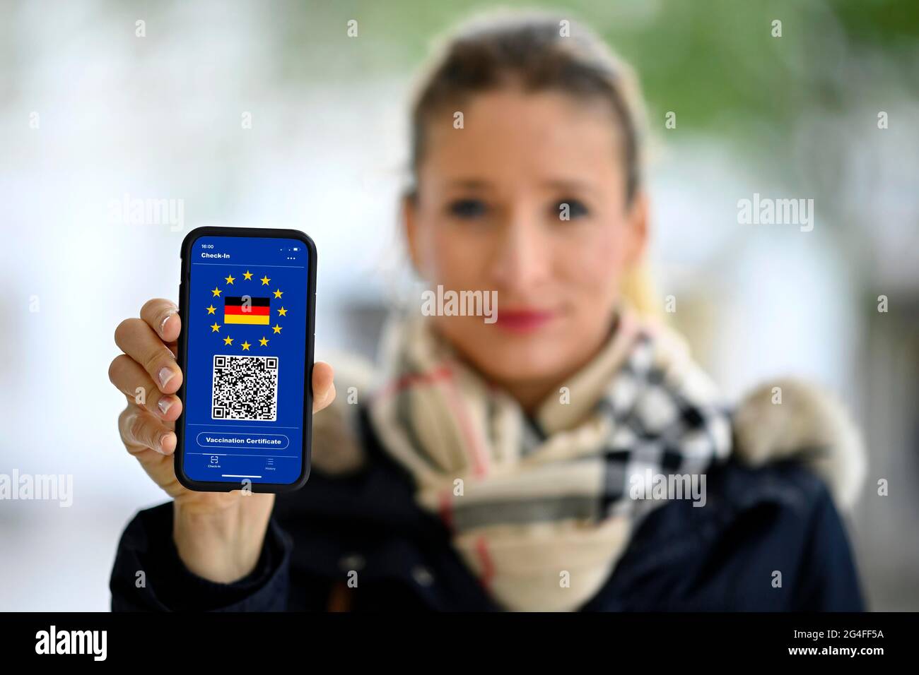 Symbol photo vaccination privilege, woman shows smartphone with digital ...