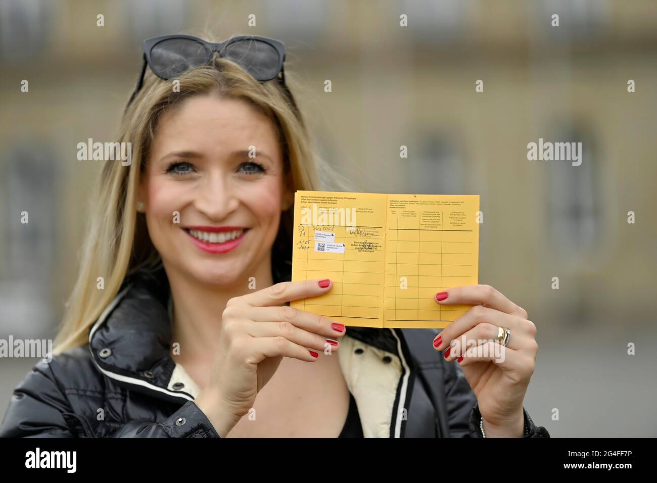 Young woman proudly showing her vaccination certificate after first and ...