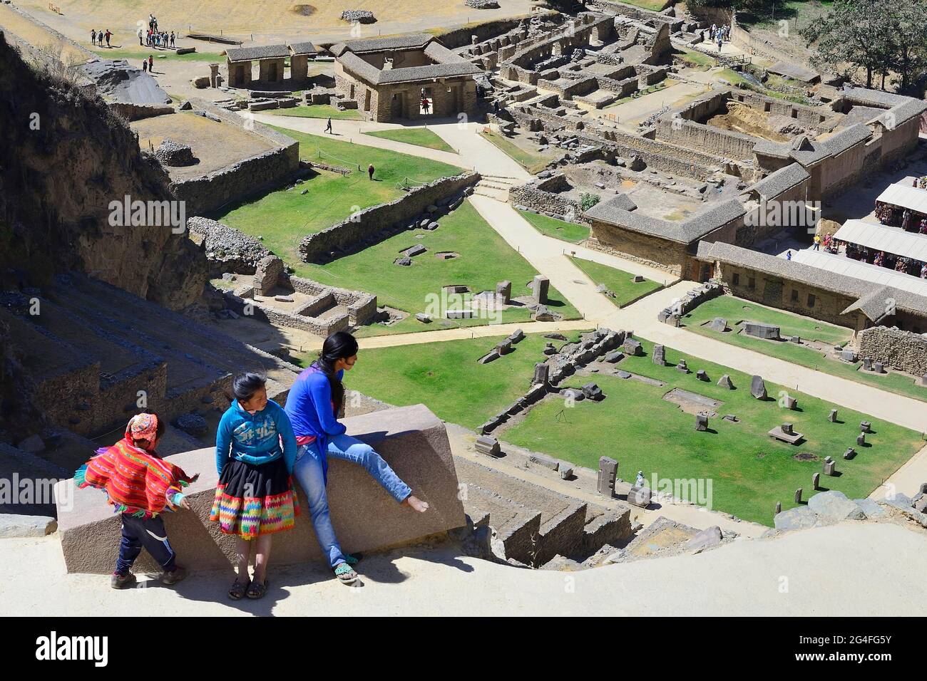 Three indigenous children in the Inca ruins, Ollantaytambo, Cusco ...