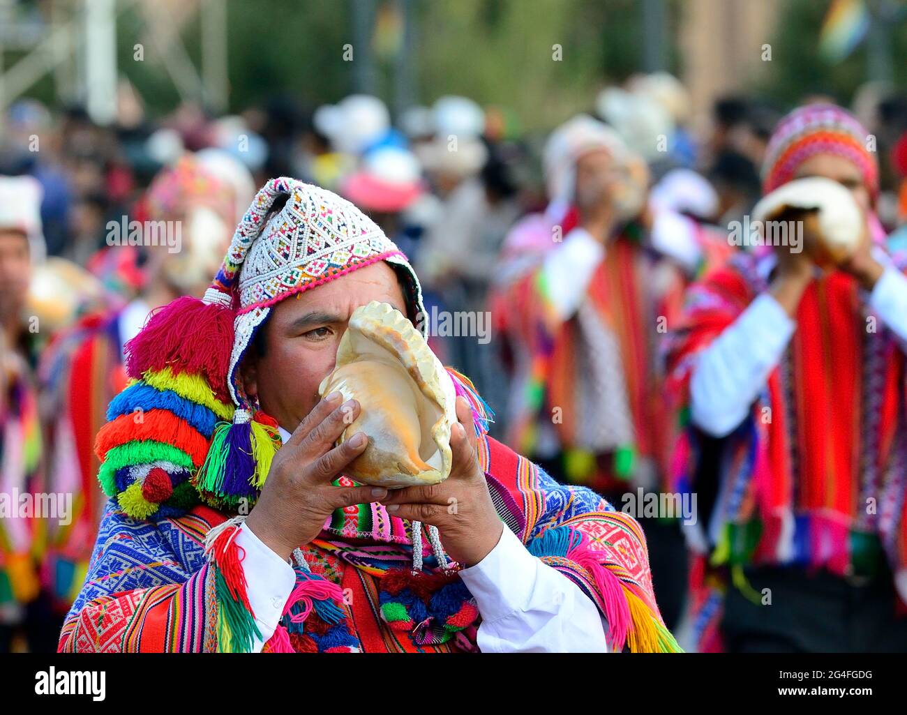 Indigenous man blows conch shell during parade on eve of Inti Raymi ...