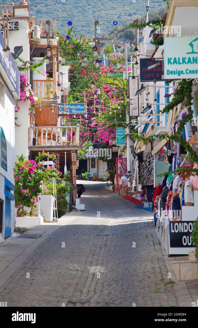 A narrow cobbled street in Kalkan, Turkey, with overhanging balconies ...