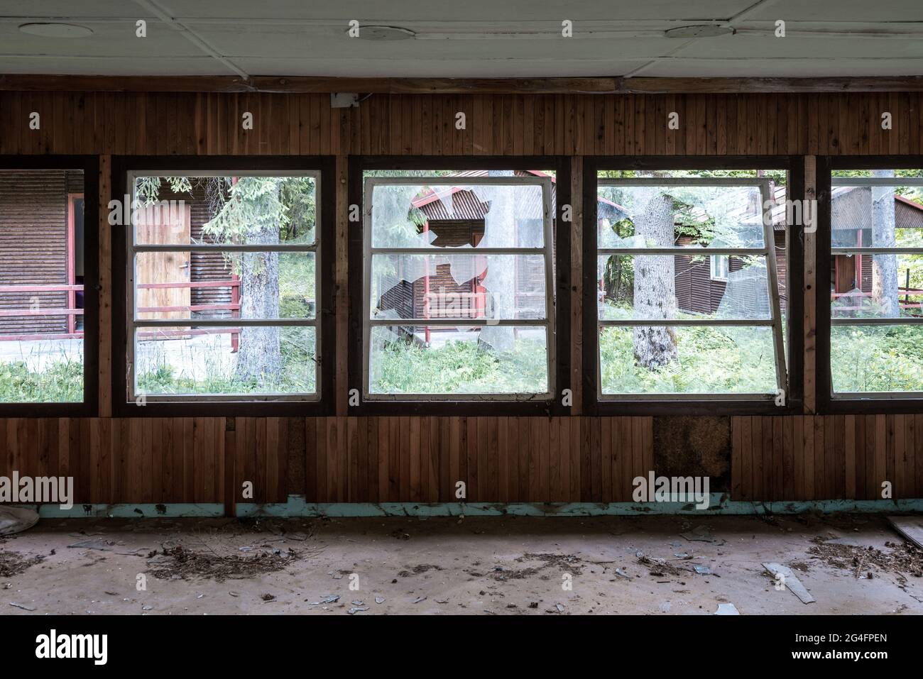 Big room in old abandoned house with all windows broken, dirt and ...