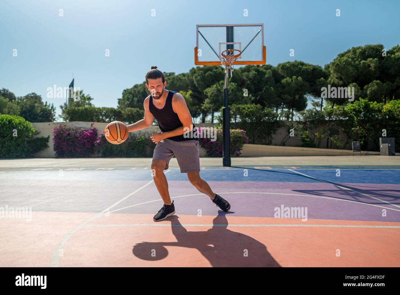 Fit male playing basketball outdoor, sunny weather, modern playground ...