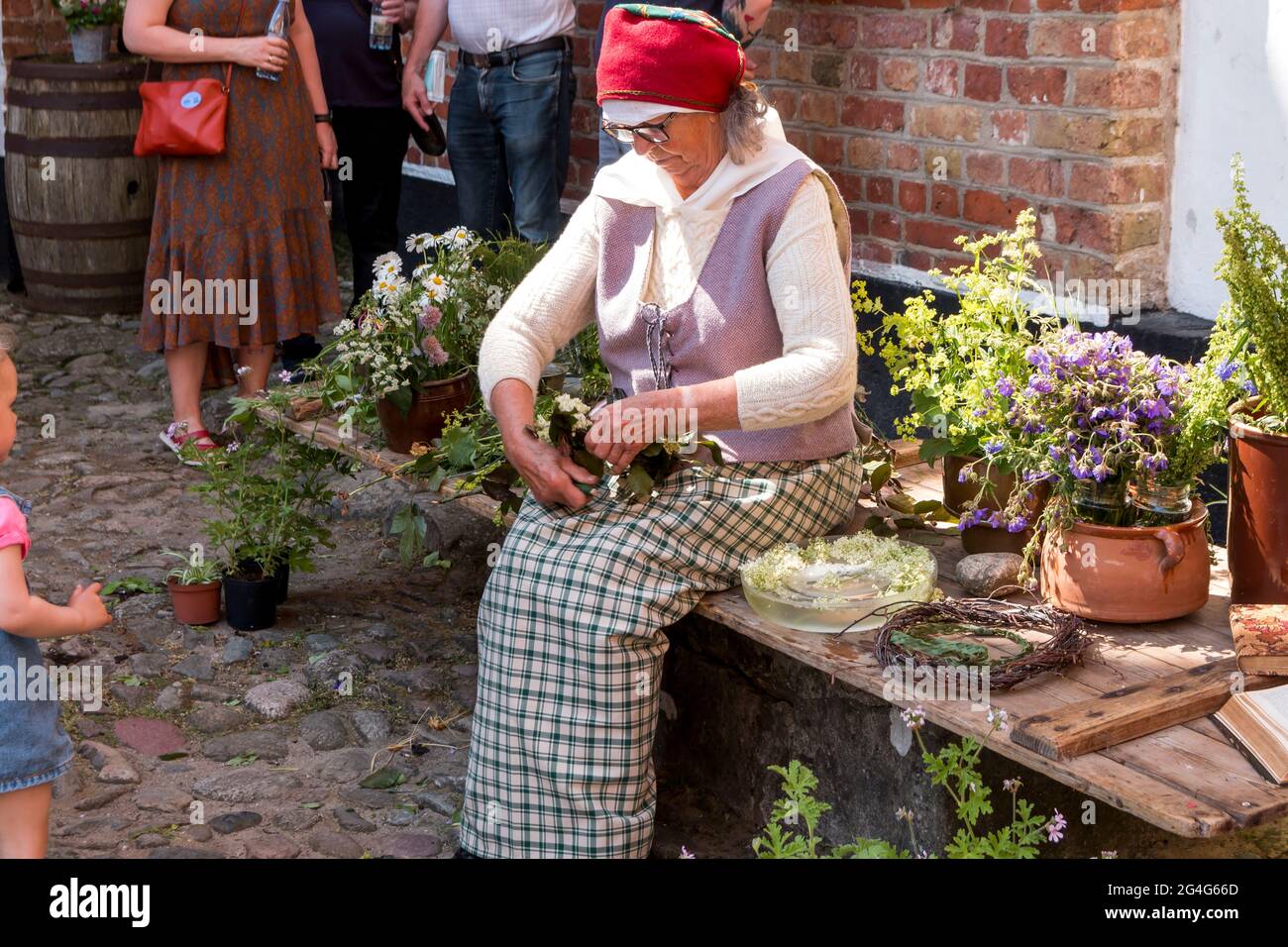 Auning, Denmark - 19 June 2021: Woman from the 18th century sits and ...