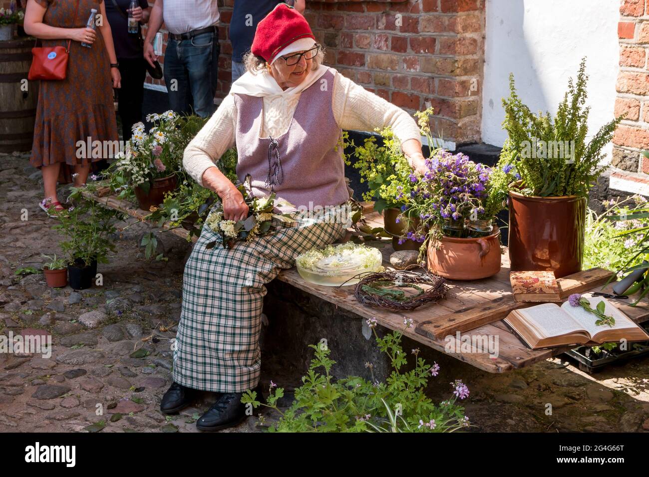 Auning, Denmark - 19 June 2021: Woman from the 18th century sits and ...